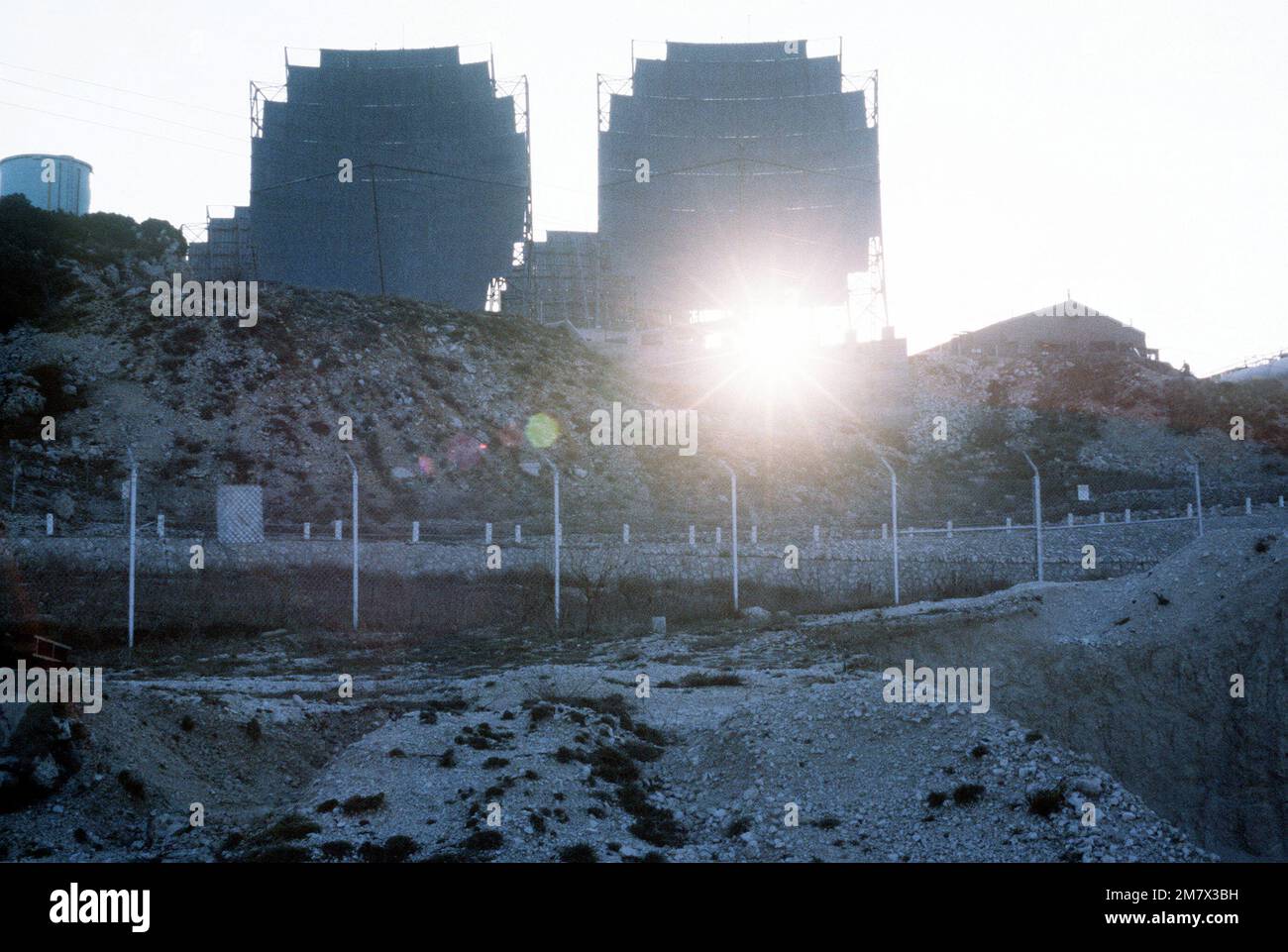 The rising sun outlines a tropo antenna at a communication site above ...