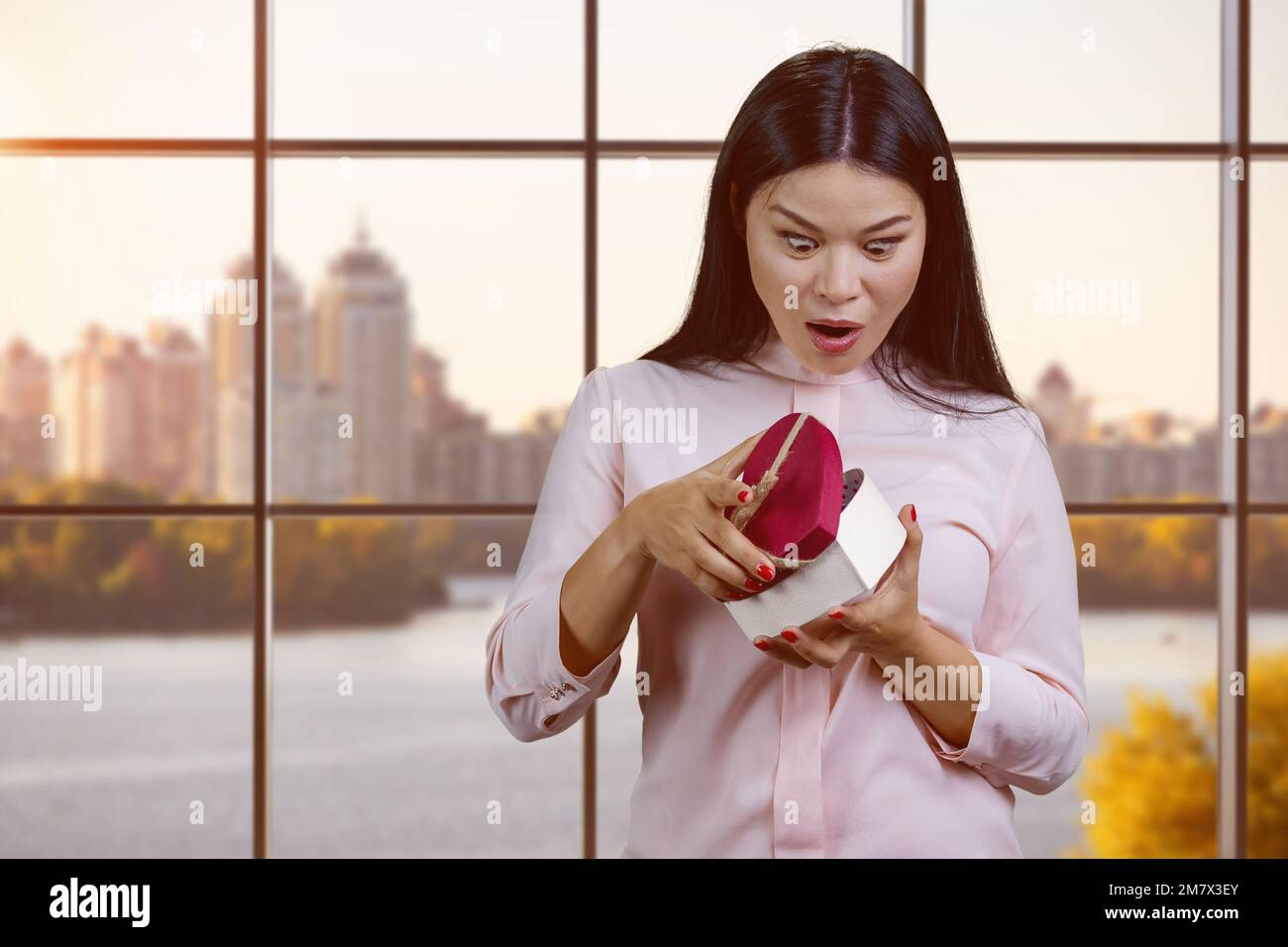 Shocked young asian woman is opening heart shape gift box. Checkered ...