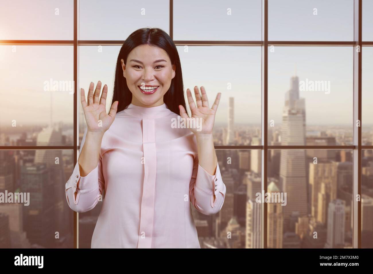 Portrait of young asian woman showing her hands. Checkered windows and ...