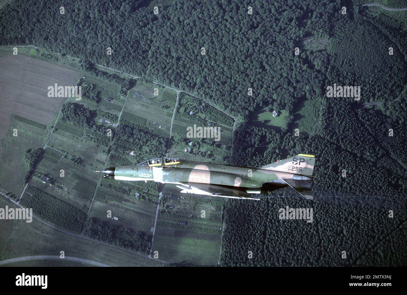 A left side view of an F-4G Phantom II aircraft banking to the right ...
