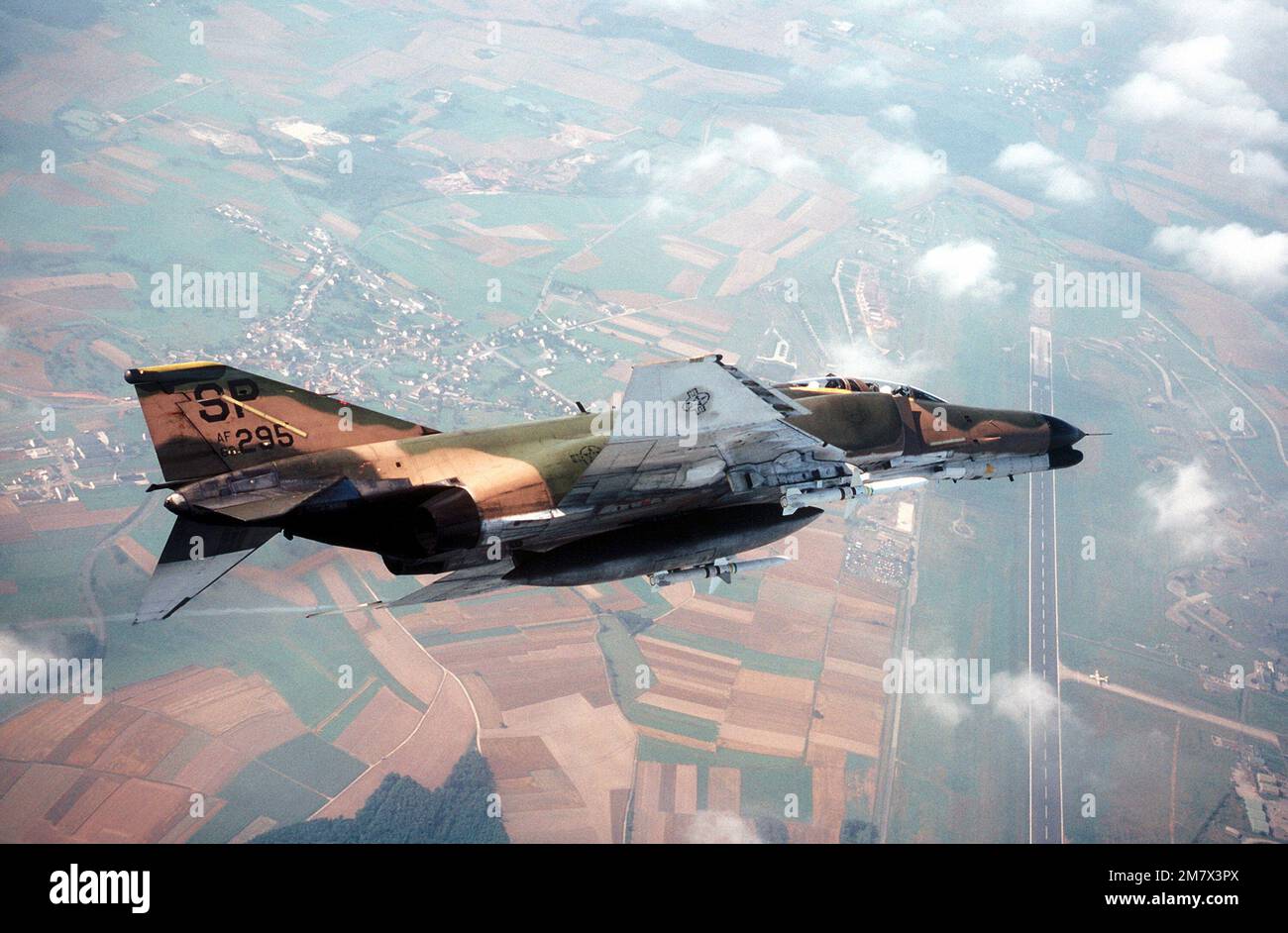 An air-to-air right side view of an F-4G Phantom II aircraft banking to ...