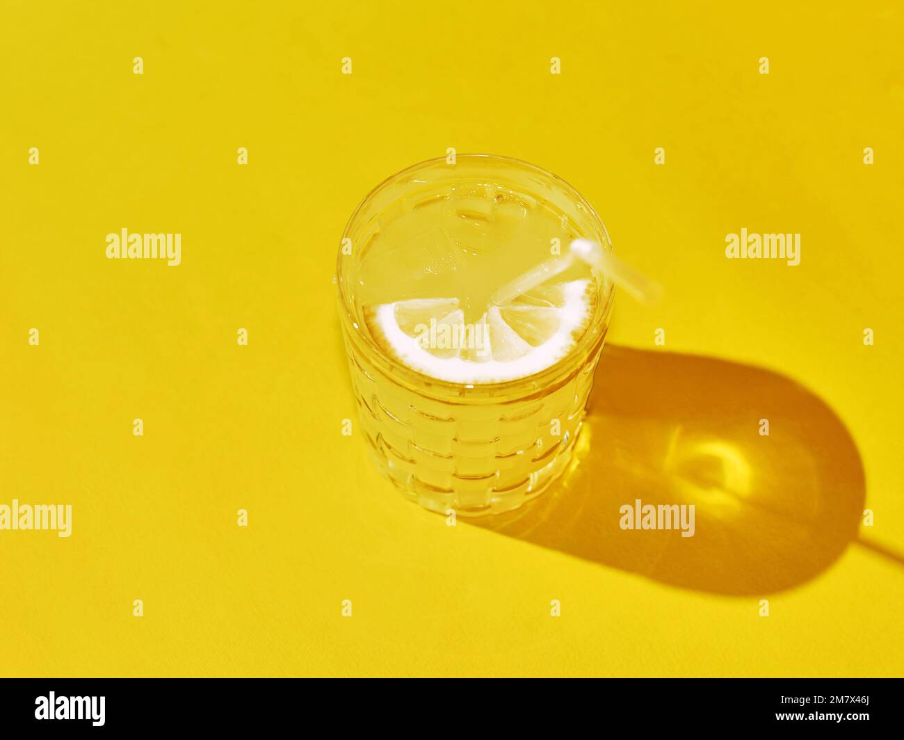 Yellow lemonade on solid background with soda and lemon. Close-up view ...