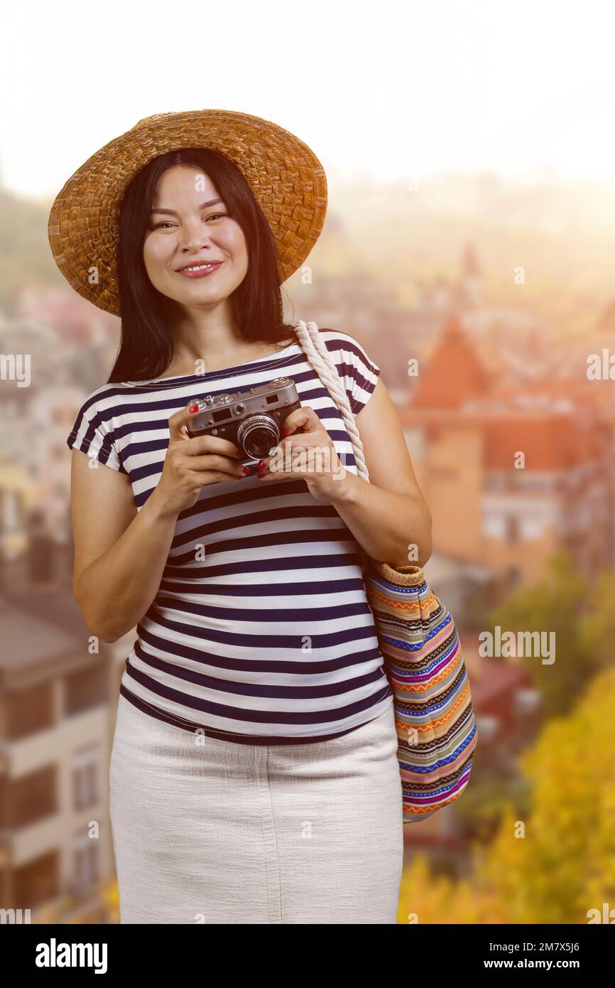 Portrait of asian female tourist in straw hat is holding a vintage ...