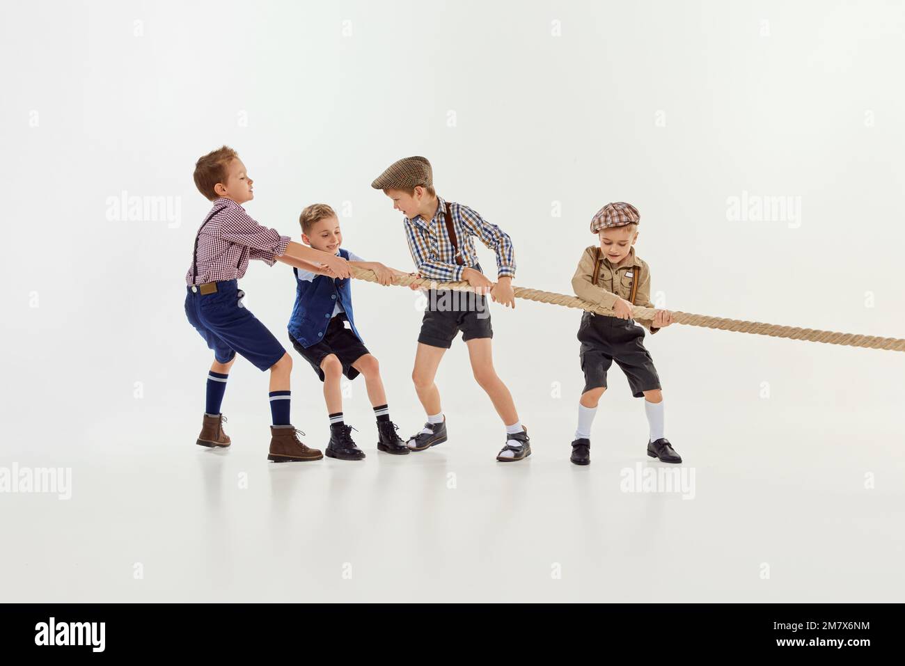 Having fun. Group of little boys, children playing together, pulling ...