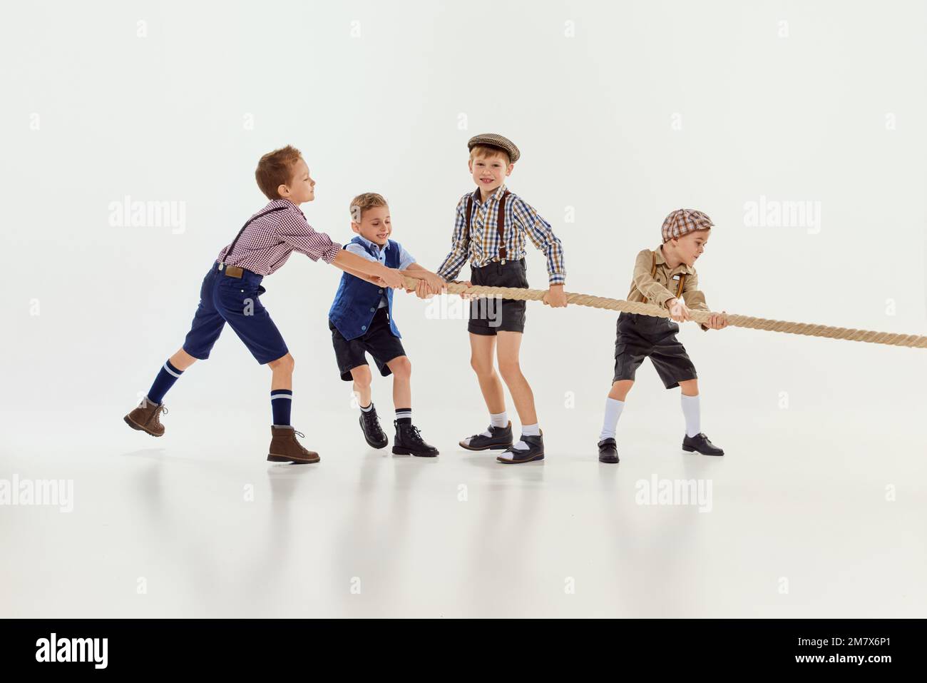 Sportive game. Group of little boys, children playing together, pulling ...
