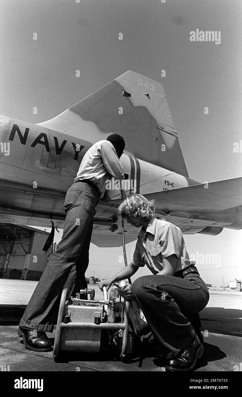 Airmen (AN) Trent Smith and Karla Lallo service an F-5E Tiger II ...