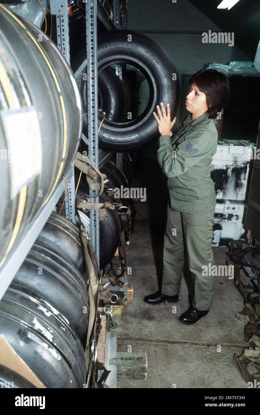 SGT. Jamie Prickett removes a tire from a rack in the supply section ...