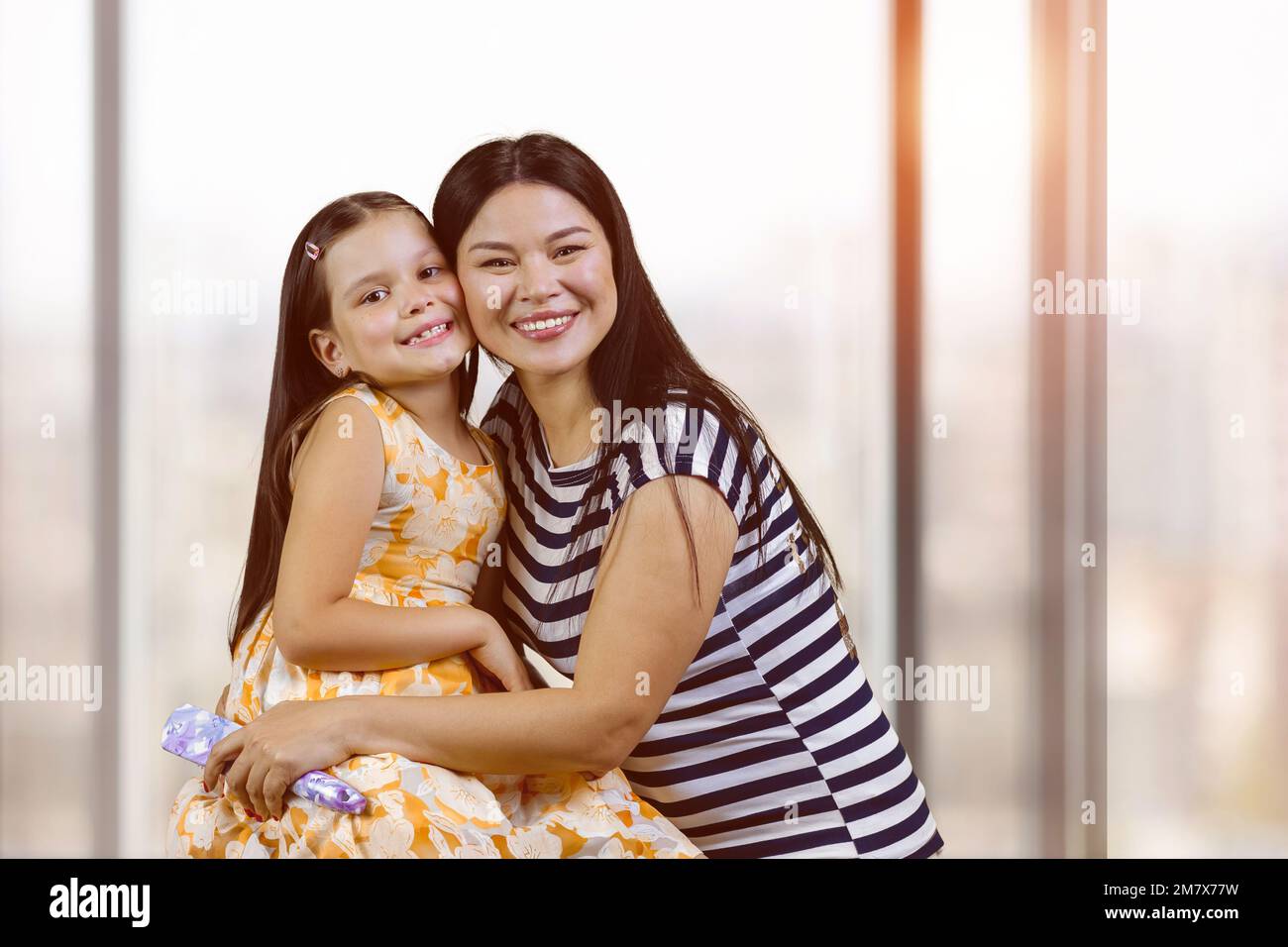 Portrait of a happy asian woman with her adopted caucasian little ...