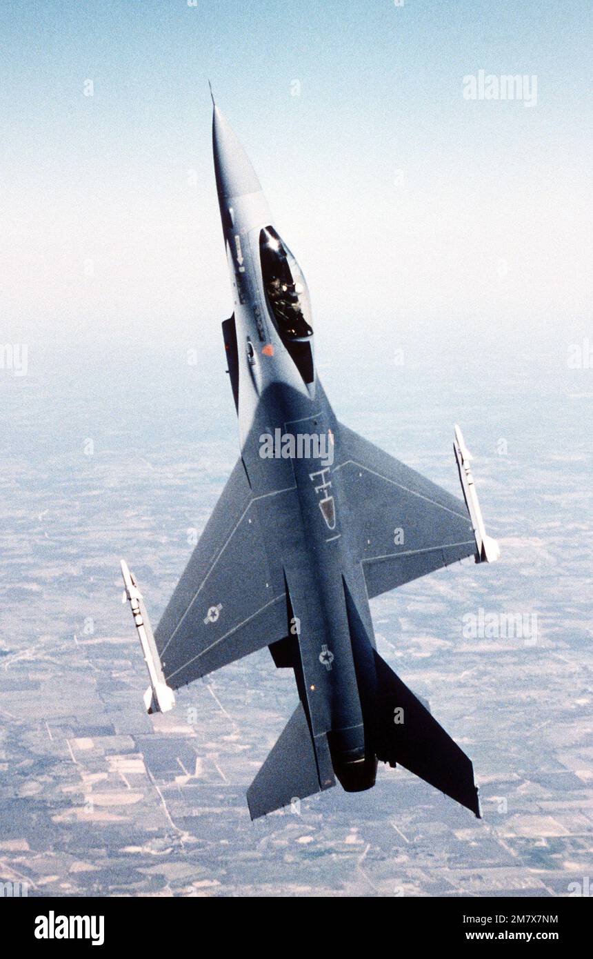 An air-to-air view of an F-16 Fighting Falcon aircraft in a vertical ...