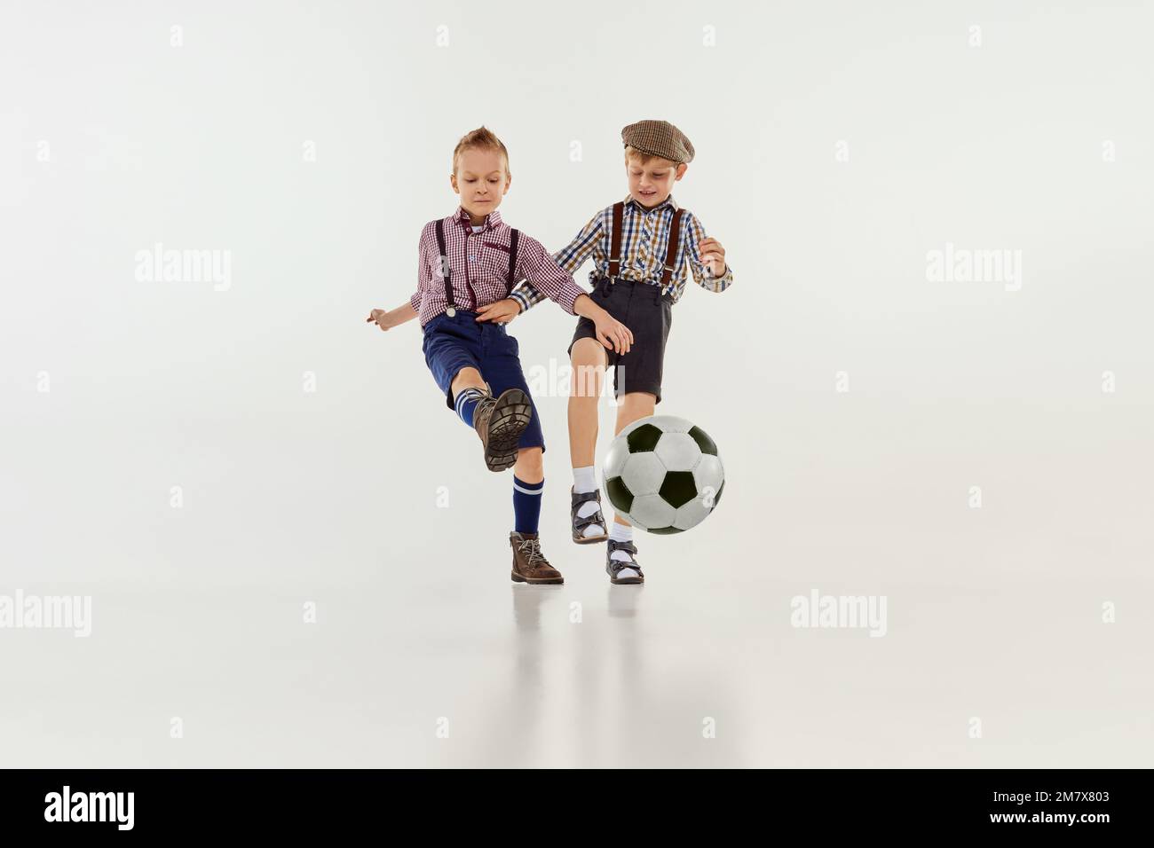 Dribbling. Boys, children in classical retro clothes playing football ...