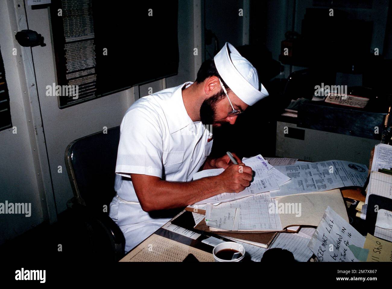 A crewman works in an office on the aircraft carrier USS AMERICA (CV 66 ...