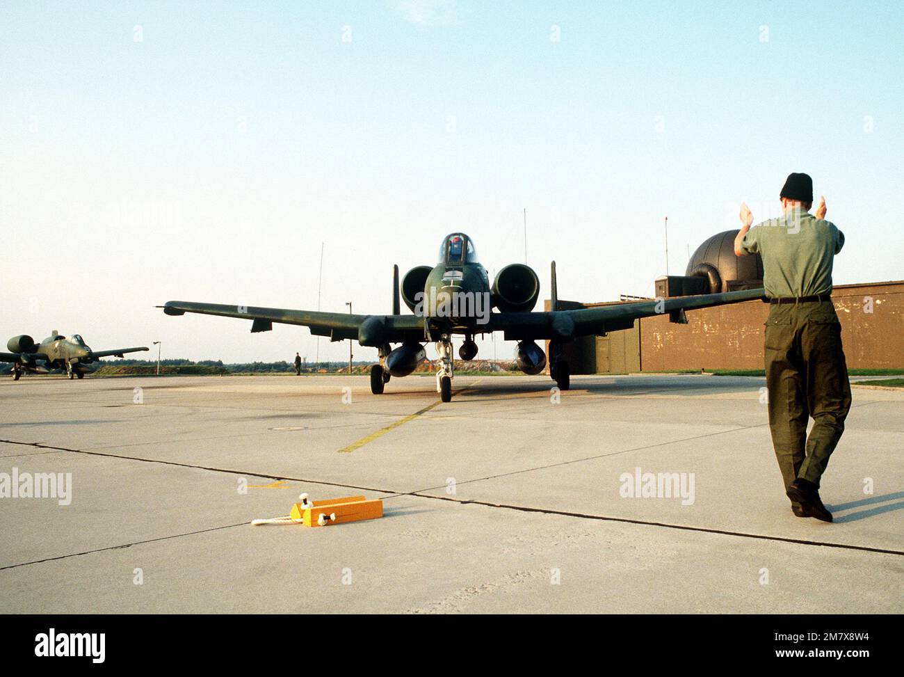 An A-10 Thunderbolt II aircraft is marshalled off the runway apron upon ...