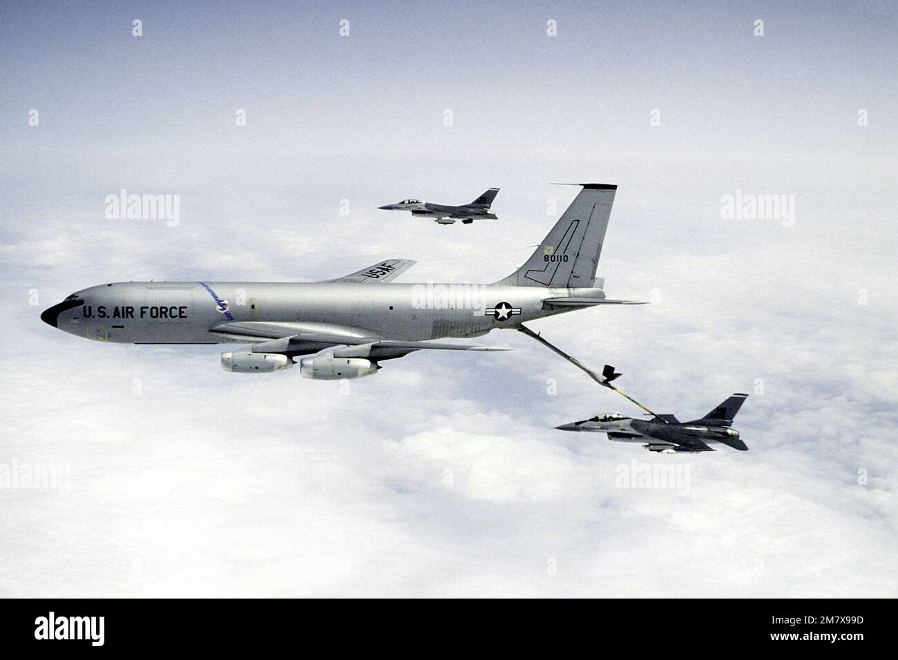 A left side view of a KC-135 Stratotanker aircraft refueling an F-16 ...