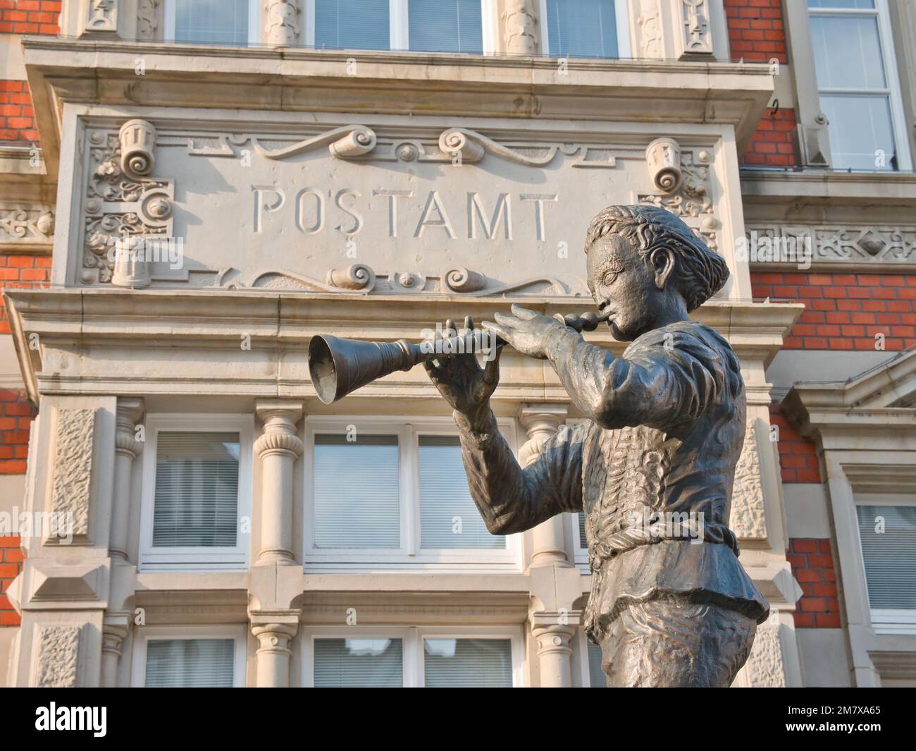 A statue of the Pied Piper from Hameln and the lettering "Postamt" in ...