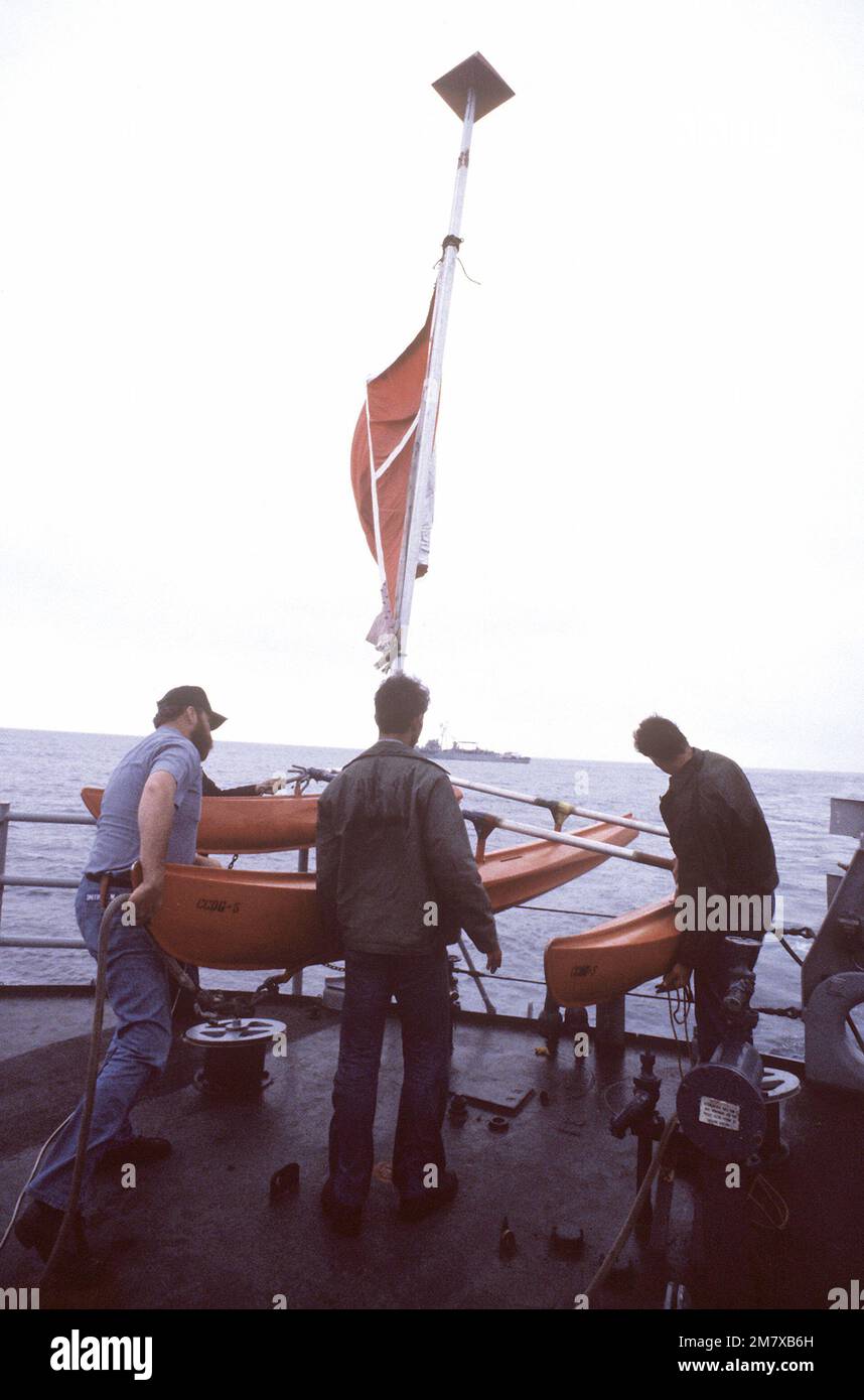 Crewmen prepare to launch a tow target from the aft deck of the guided ...