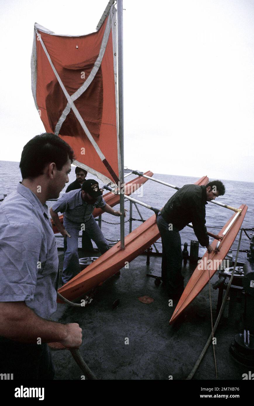 Crewmen prepare to launch a tow target from the aft deck of the guided ...