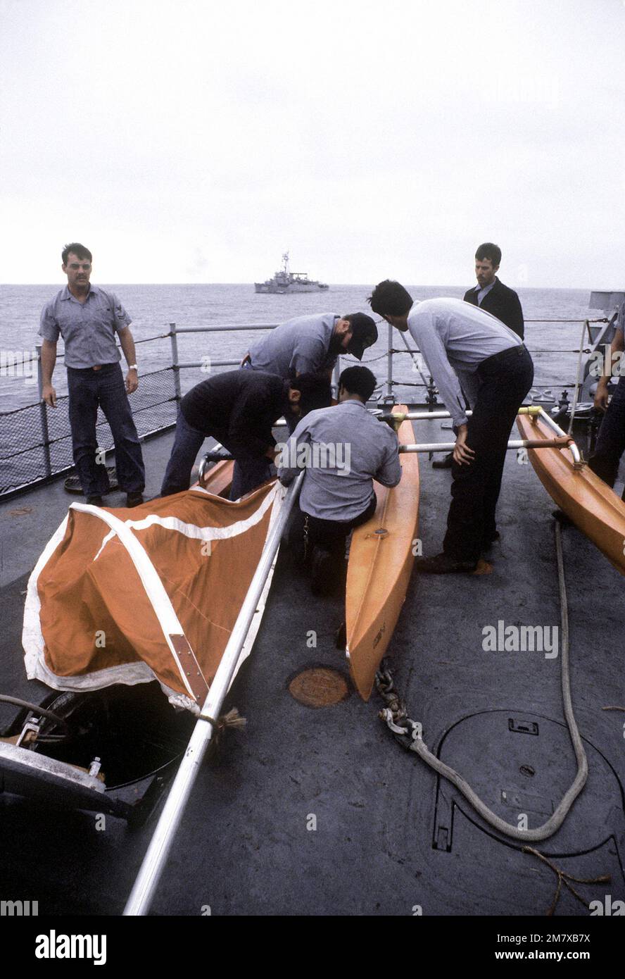 Crewmen prepare to launch a tow target from the aft deck of the guided ...