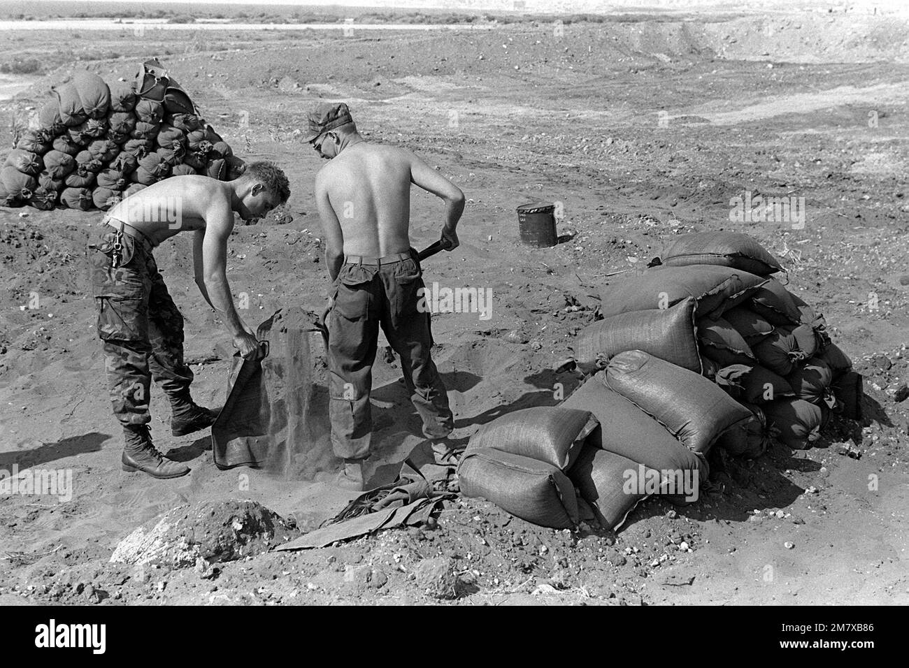U.S. Marines fill sandbags that will be used around the perimeter of ...