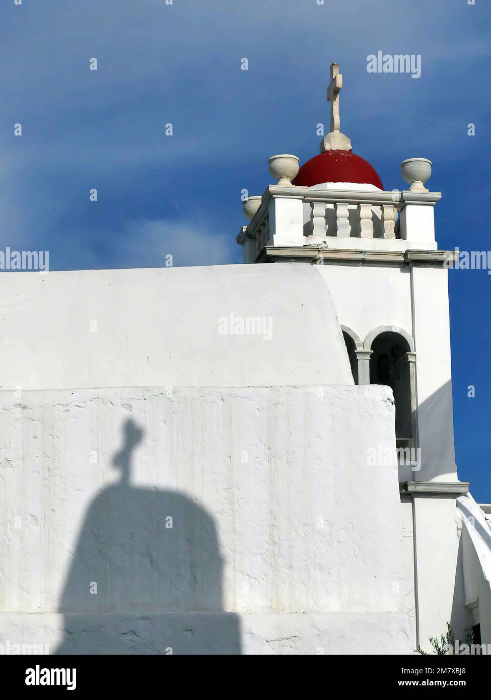 A white-painted historical building and shadow of cross on the wall ...