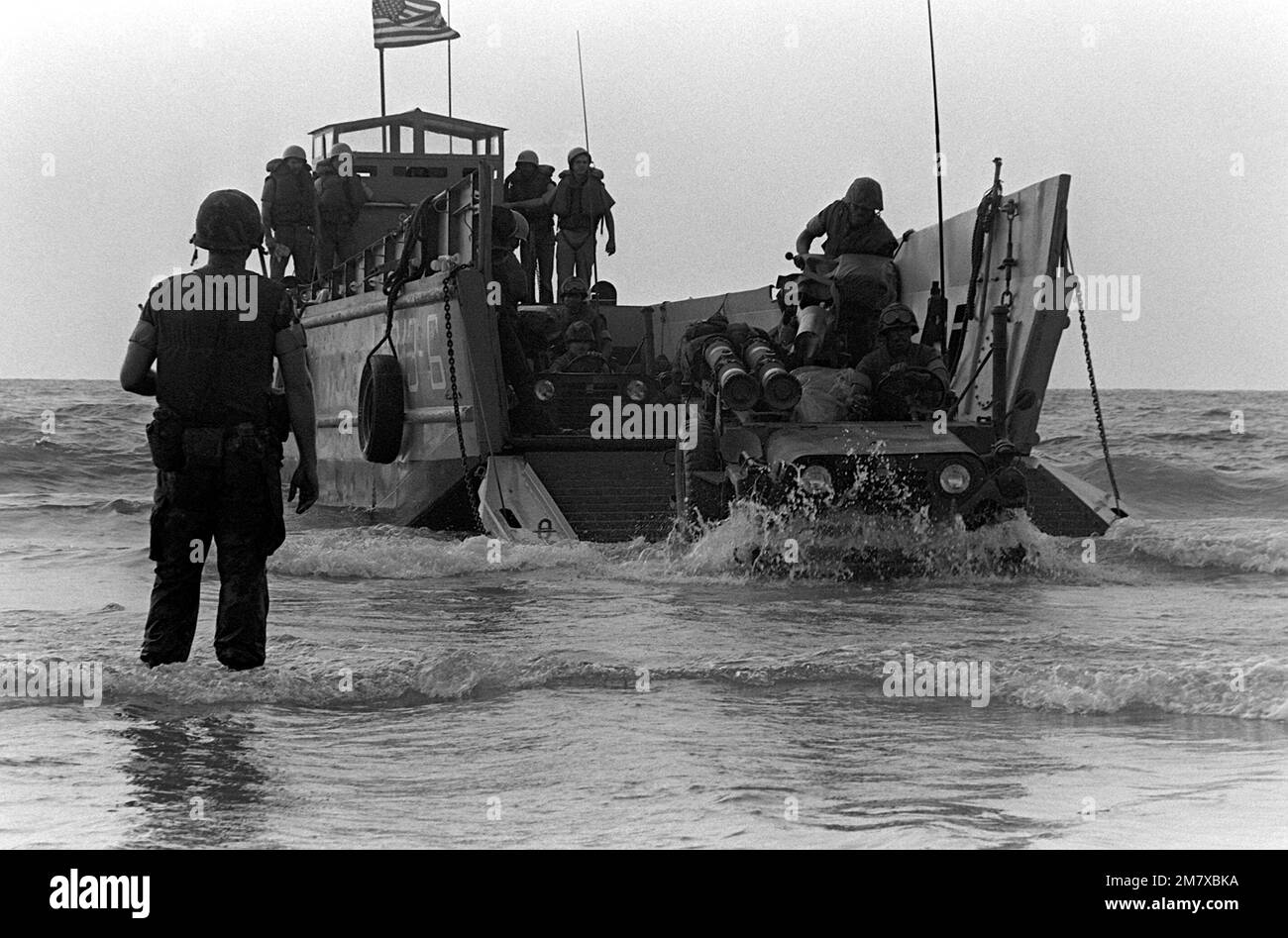A Marine's jeep rolls down the ramp of a utility landing craft during ...