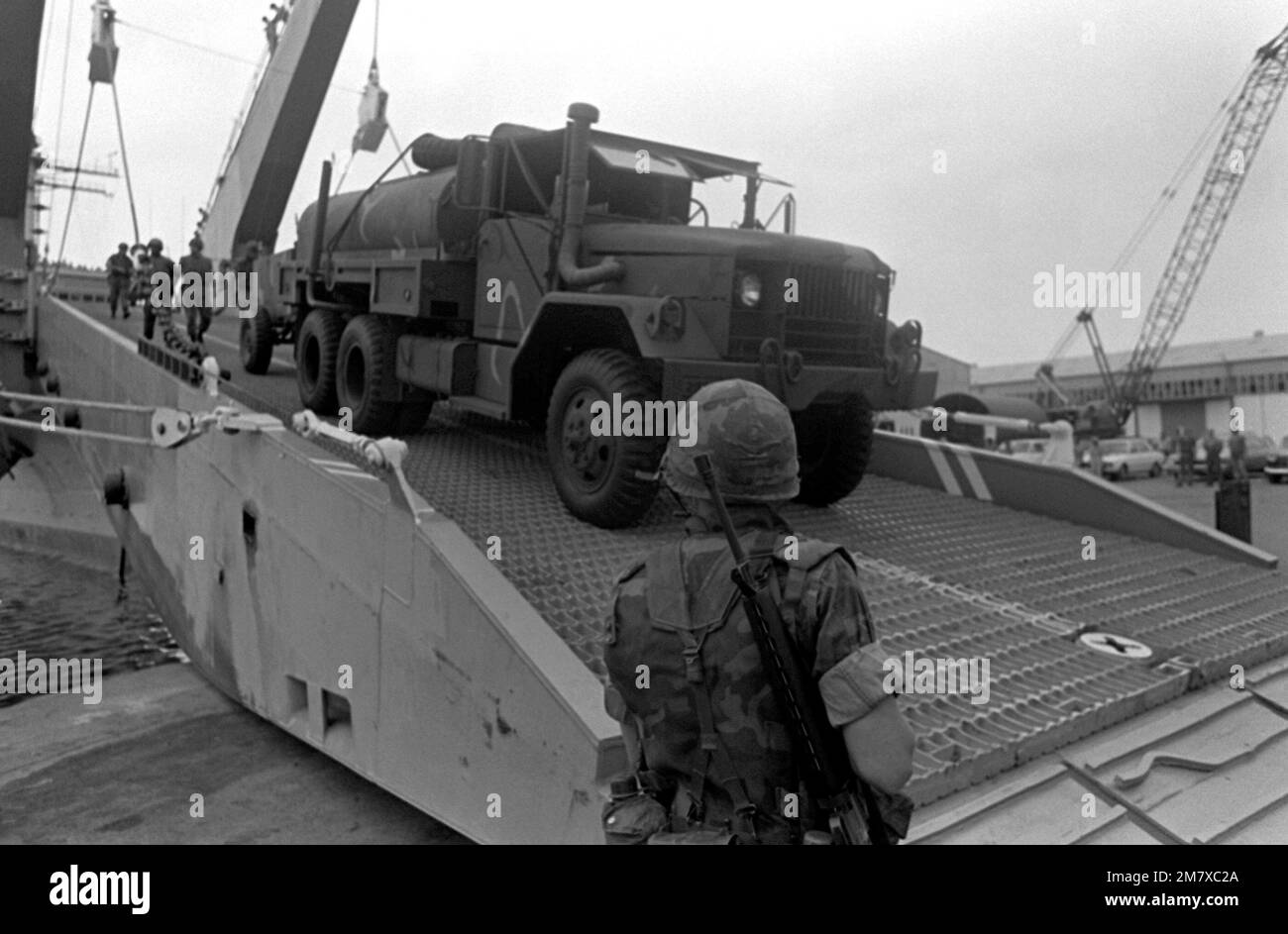 A Marine vehicle rolls down the bow ramp of the tank landing ship USS ...