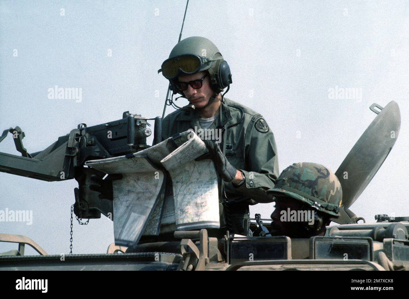A U.S. Army captain stands in the turret of his armored personnel ...