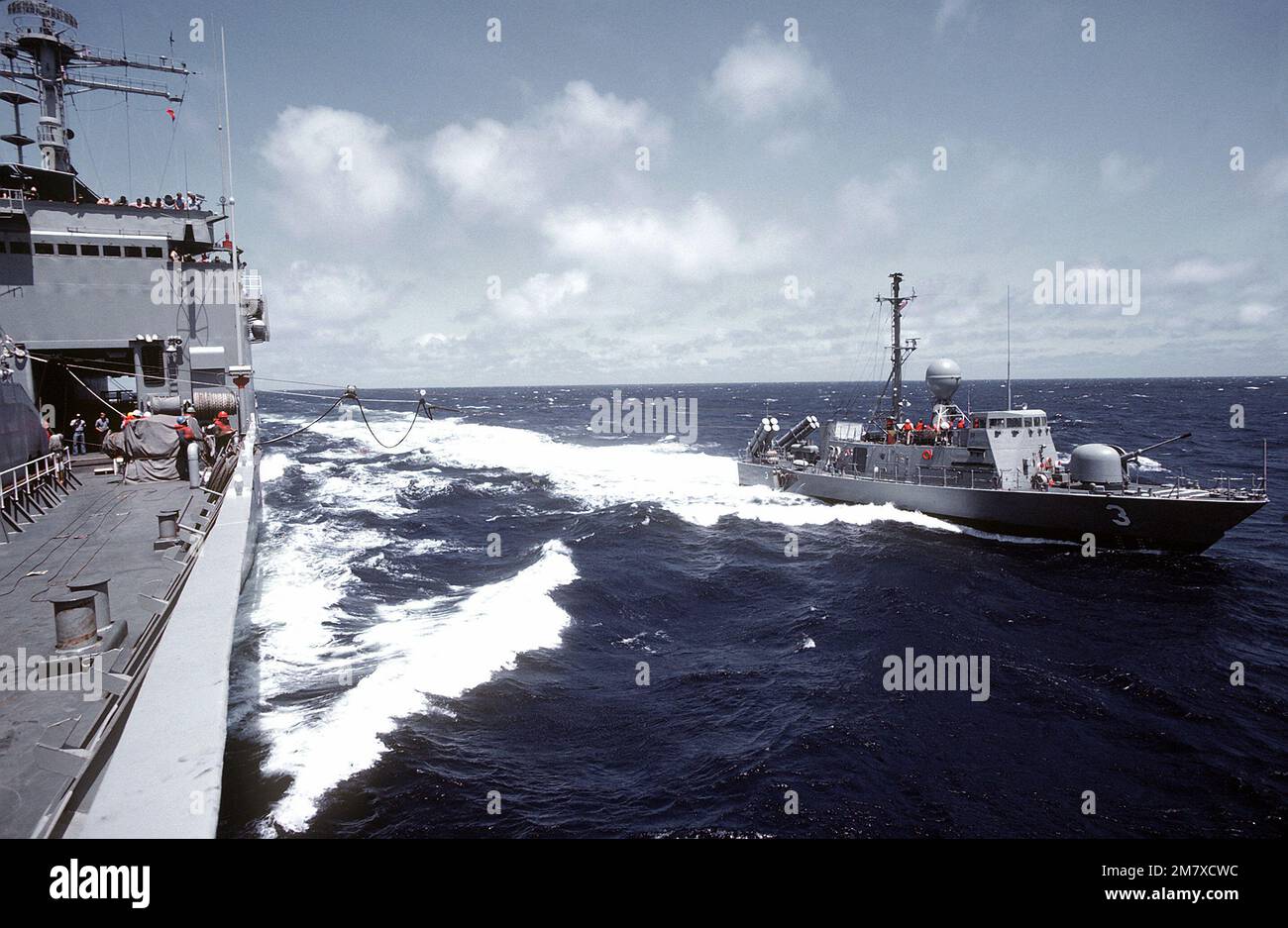 A highline is connected between the hydrofoil USS TAURUS (PHM-3) and a ...