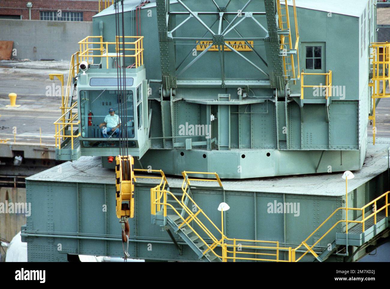 A shipyard worker operates a crane during the overhauling of the guided ...