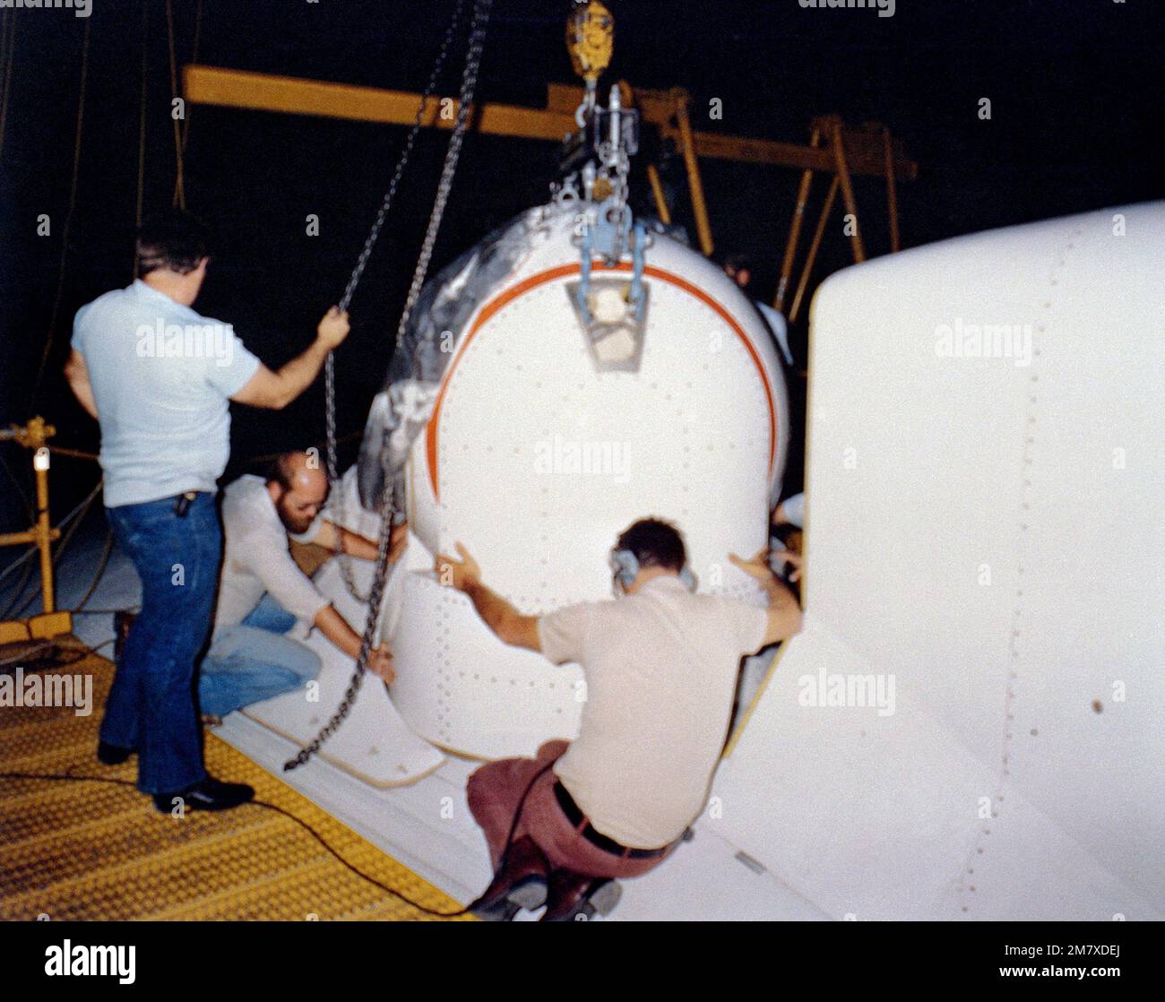 Workmen prepare to install a laser pointing telescope on the top of the ...