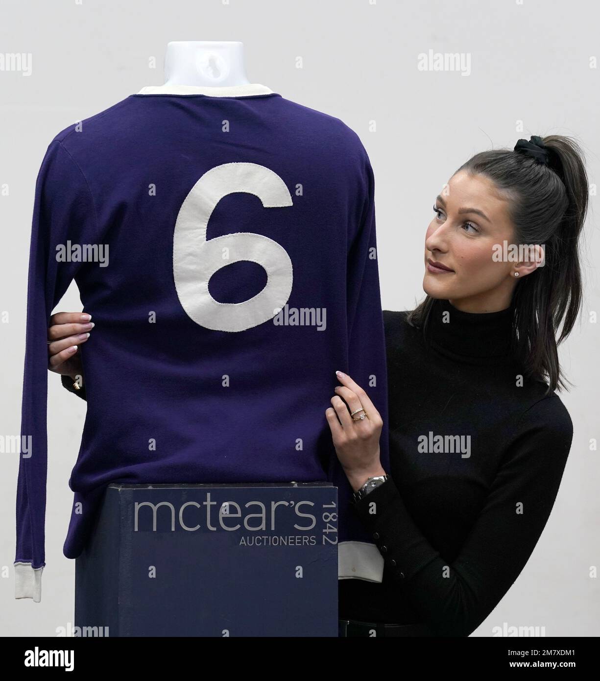 Auctioneer Amy Cameron with Jim Baxter's match worn jersey from ...