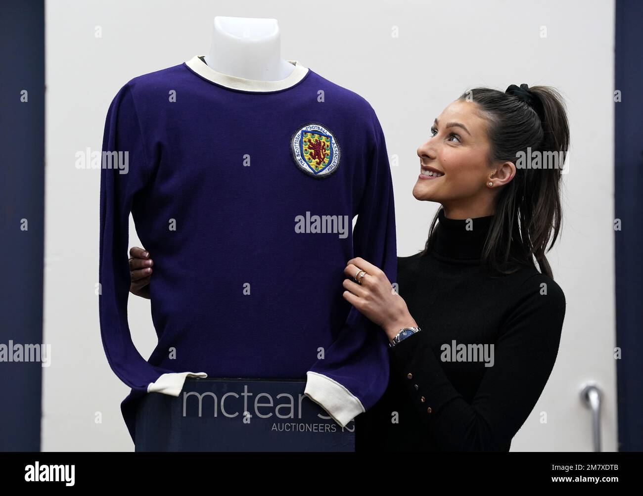 Auctioneer Amy Cameron with Jim Baxter's match worn jersey from ...