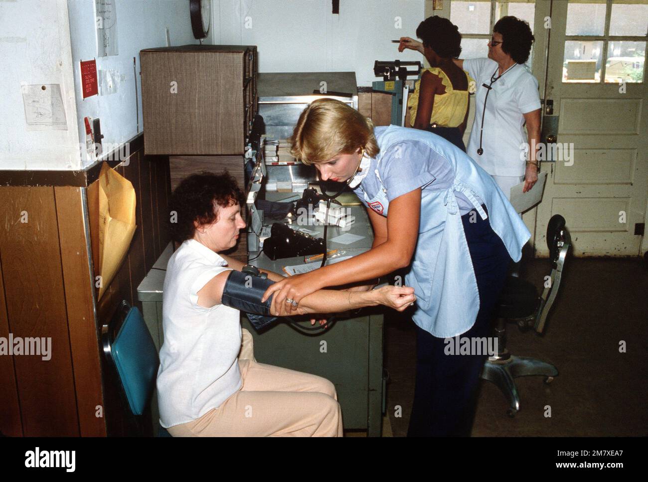 A Red Cross volunteer checks a dependent's blood pressure at the Fort ...
