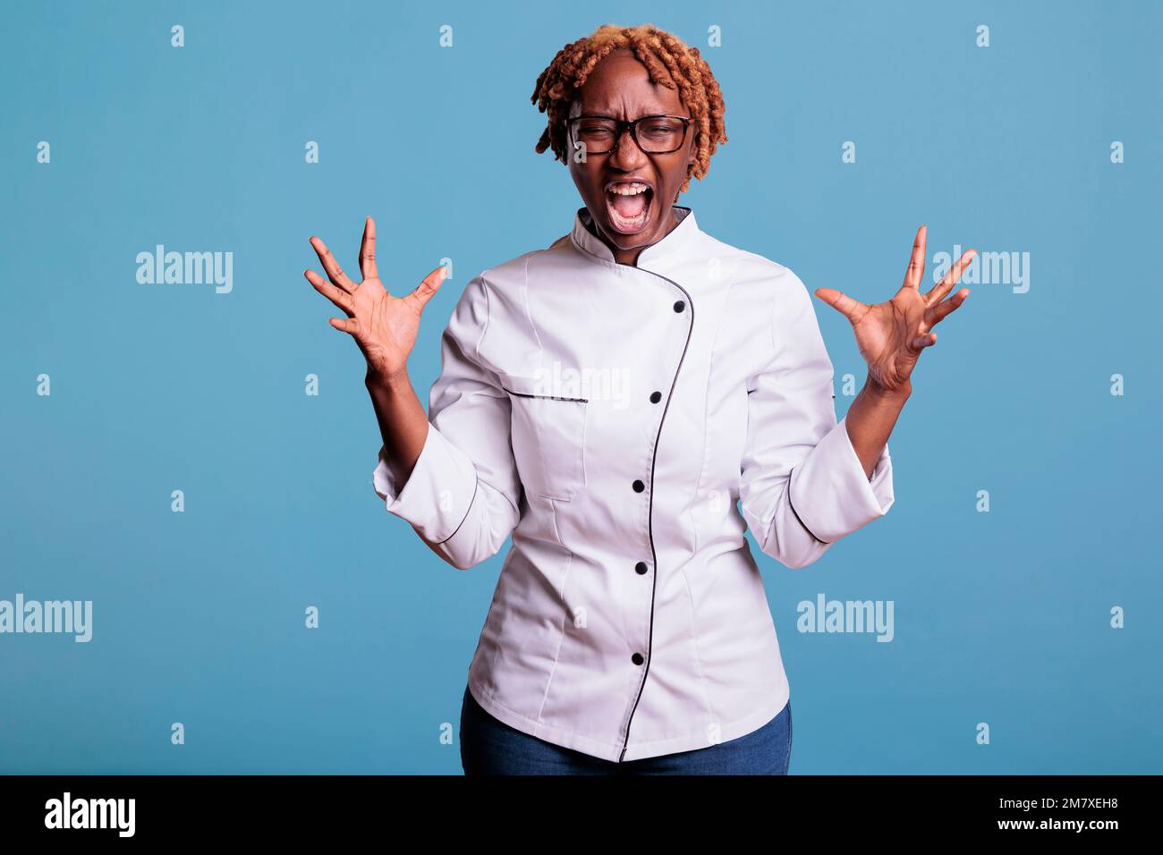 Angry african american female chef screaming loudly and waving her ...