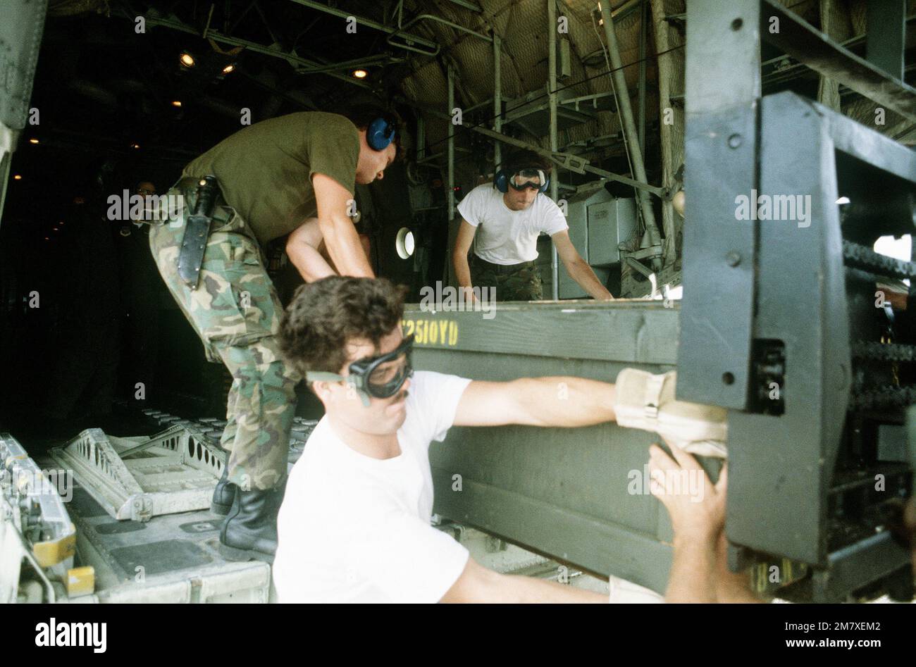 Navy seabees and Air Force personnel unload supplies from a C-130 ...