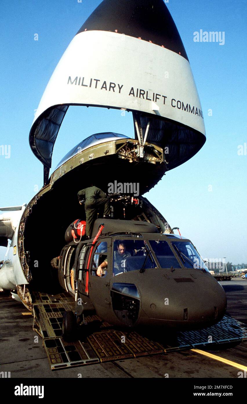 A UH-60 Blackhawk helicopter is off loaded from a C-5A Galaxy aircraft ...