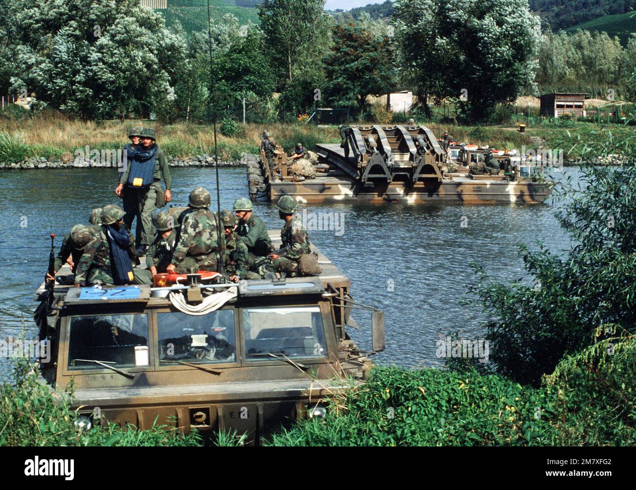 Members of the 1ST Engineers lay a pontoon bridge across the Main River ...