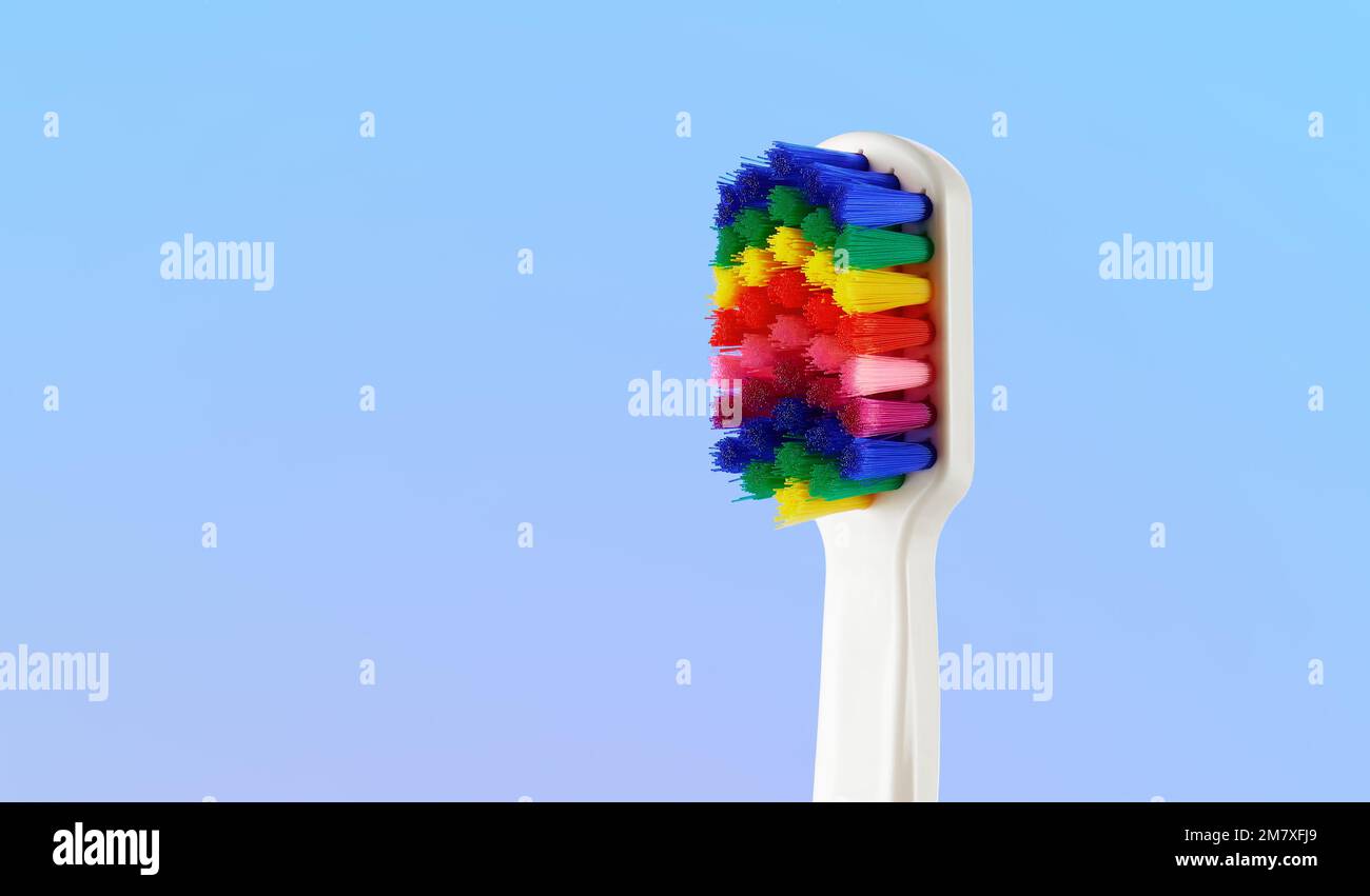 White toothbrush with multicolored bristles. Bristles in all colors of ...