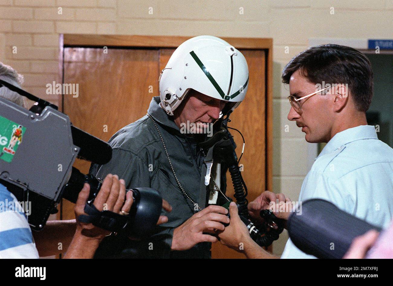 Newsman David Hartman is assisted with his equipment prior to entering ...