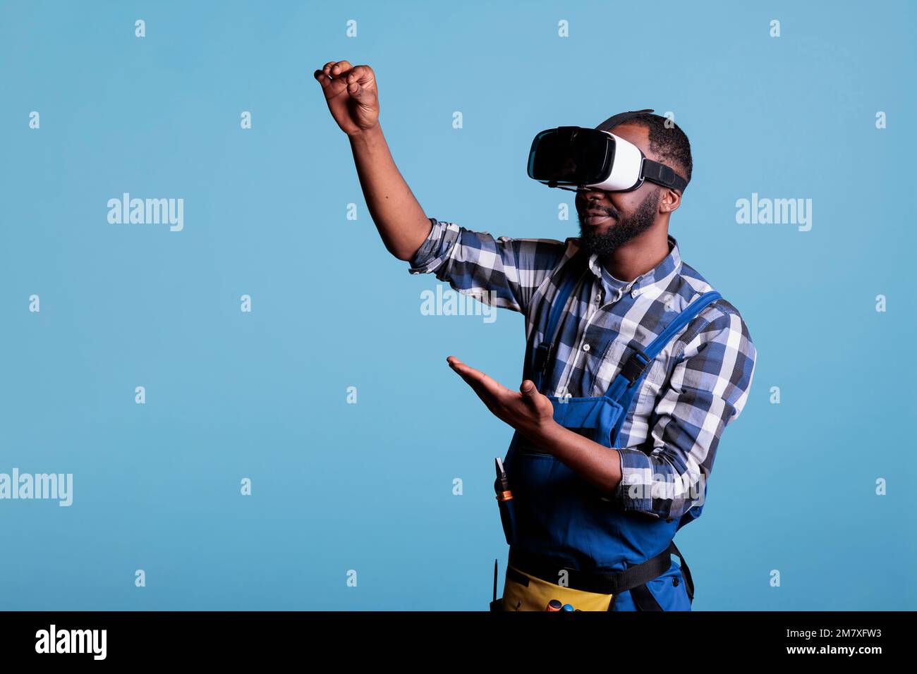 Experienced renovator using virtual reality goggles looking at plans ...