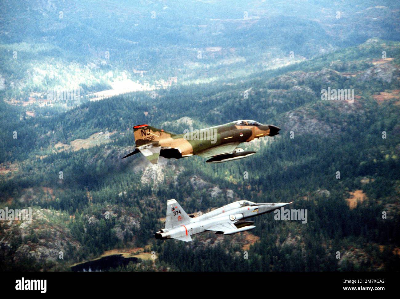 An air-to-air right side view of an F-4 Phantom II aircraft and a ...