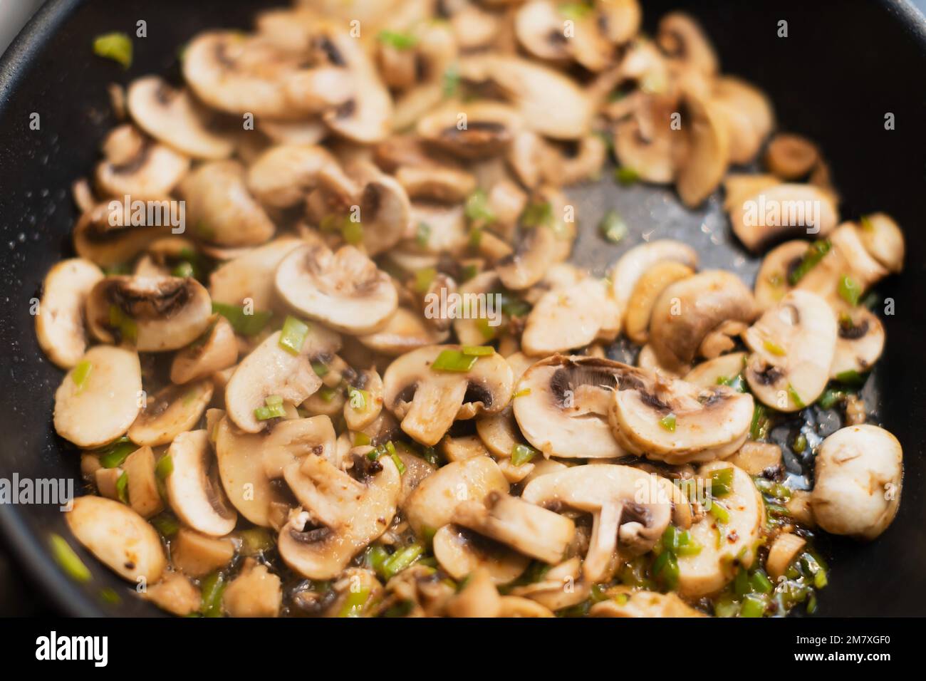 Cook champignon mushrooms in a pan with a dill Stock Photo - Alamy