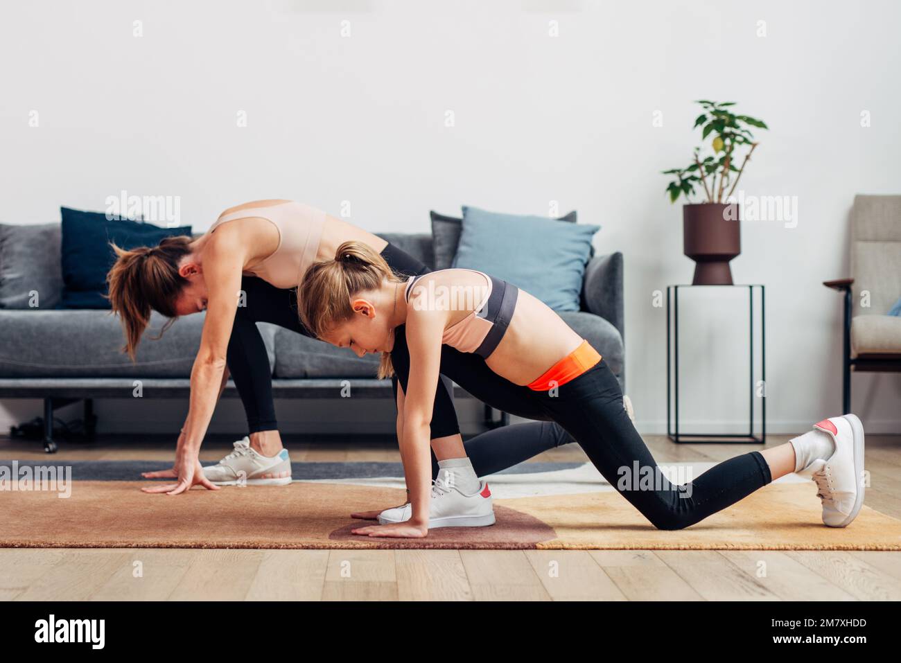 Mother and daughter working out at home, doing exercises Stock Photo ...