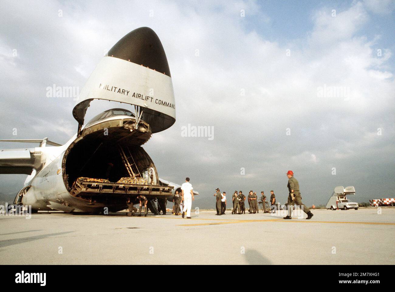 Crew members of a C-5 Galaxy aircraft unload a ramp prior to offloading ...