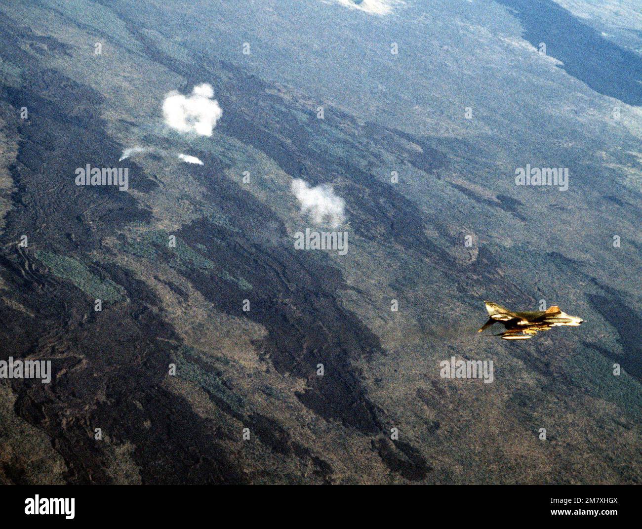 An aerial view of the range as an F-4 Phantom II aircraft flies over a ...