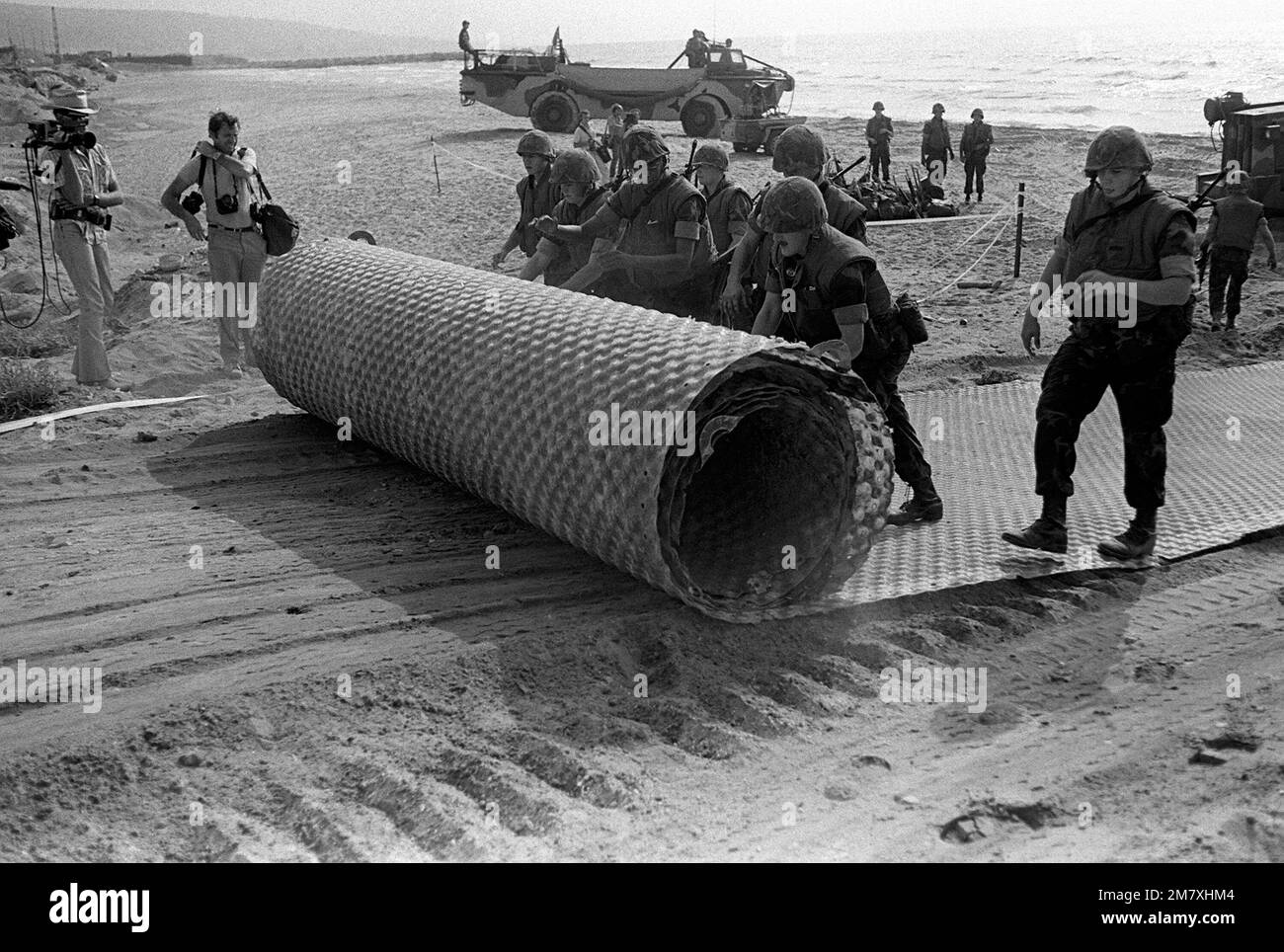 Marines of the 32nd Marine Amphibious Unit unroll matting to be used as ...