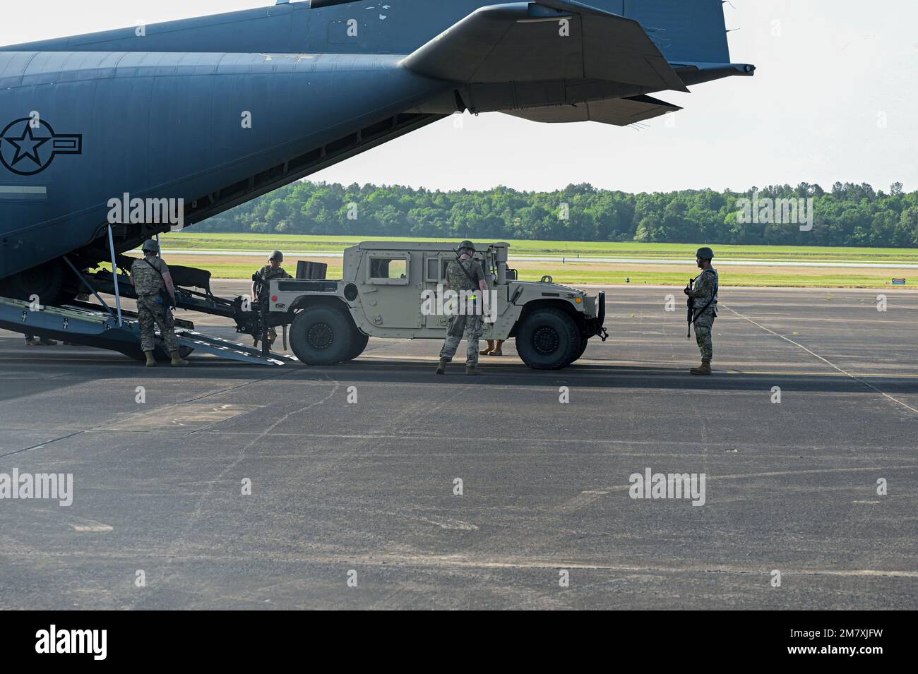 Airmen assigned to the 19th Airlift Wing load a HUMVEE onto a C-130J ...