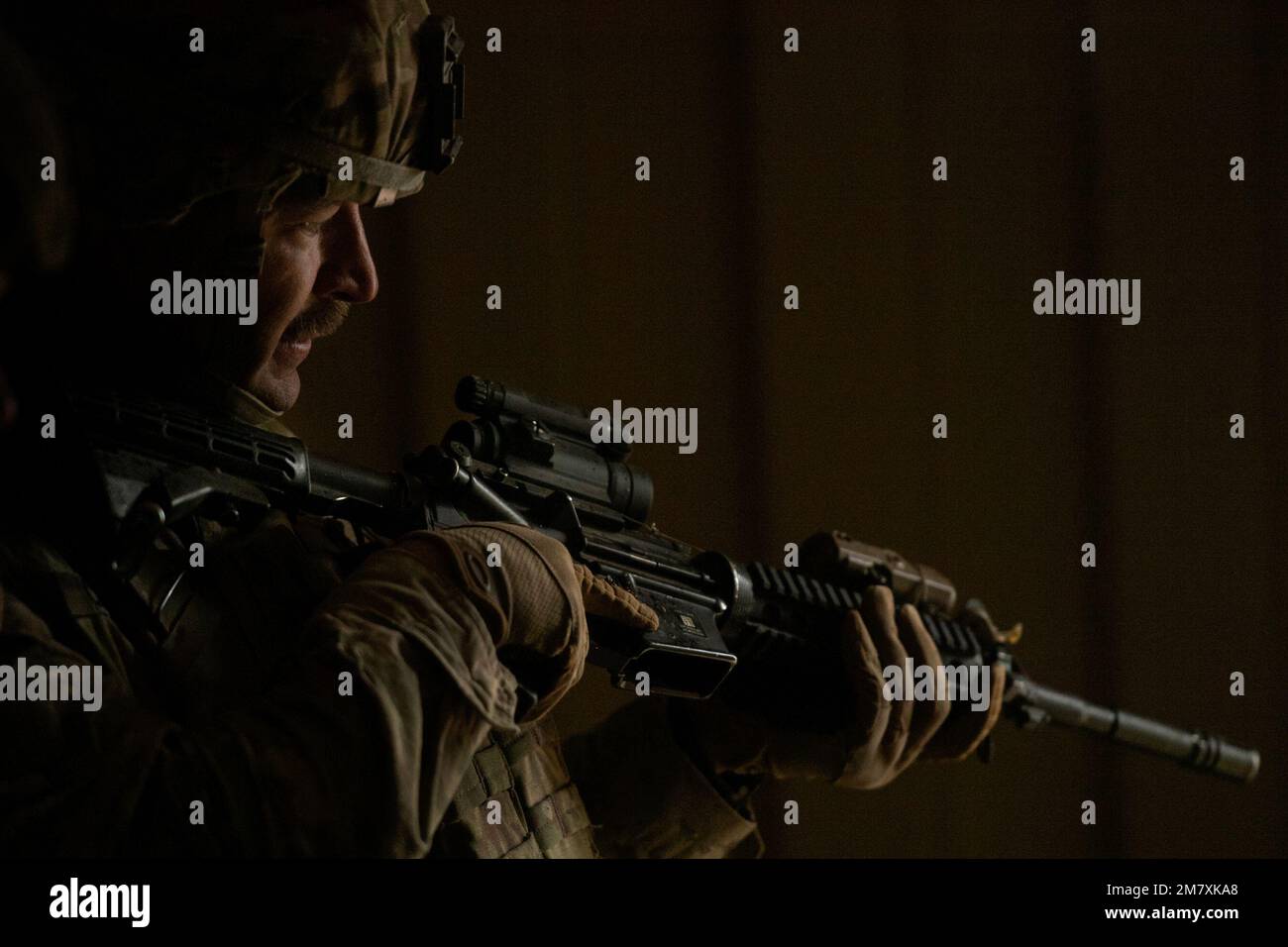 A sniper team member provides security on the entrance to the covered ...