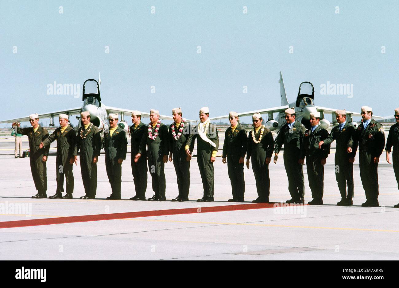A-7E Corsair aircraft pilots pay salute to a United States flag upon ...