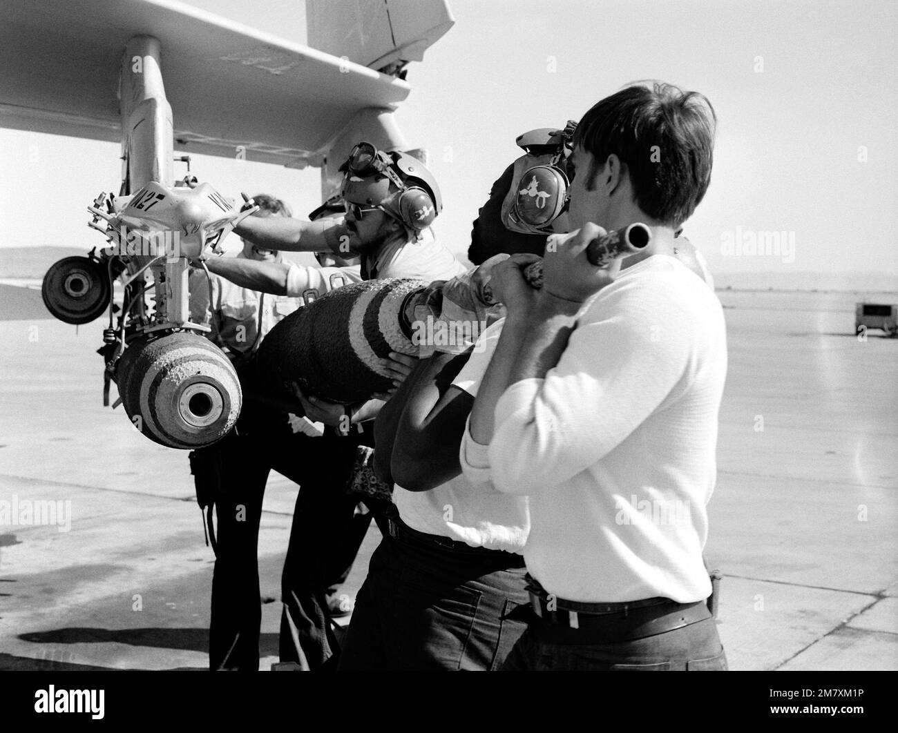 Ordnancemen from Carrier Air Wing 15 (CVW-15) arm bombs being loaded ...