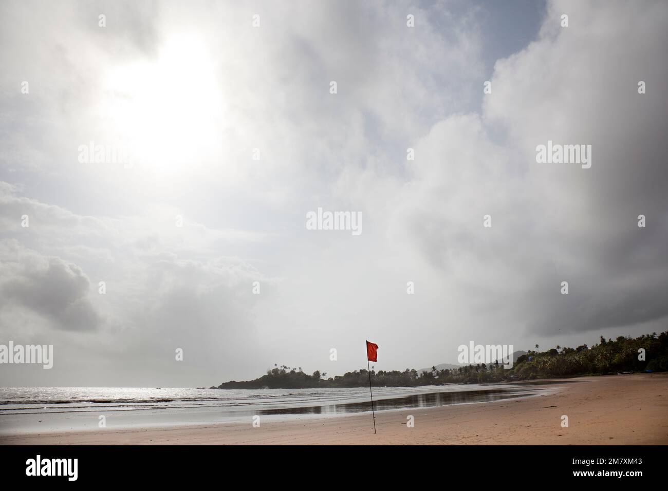Patnem beach in Goa during the monsoon. The red flag warns of danger to ...